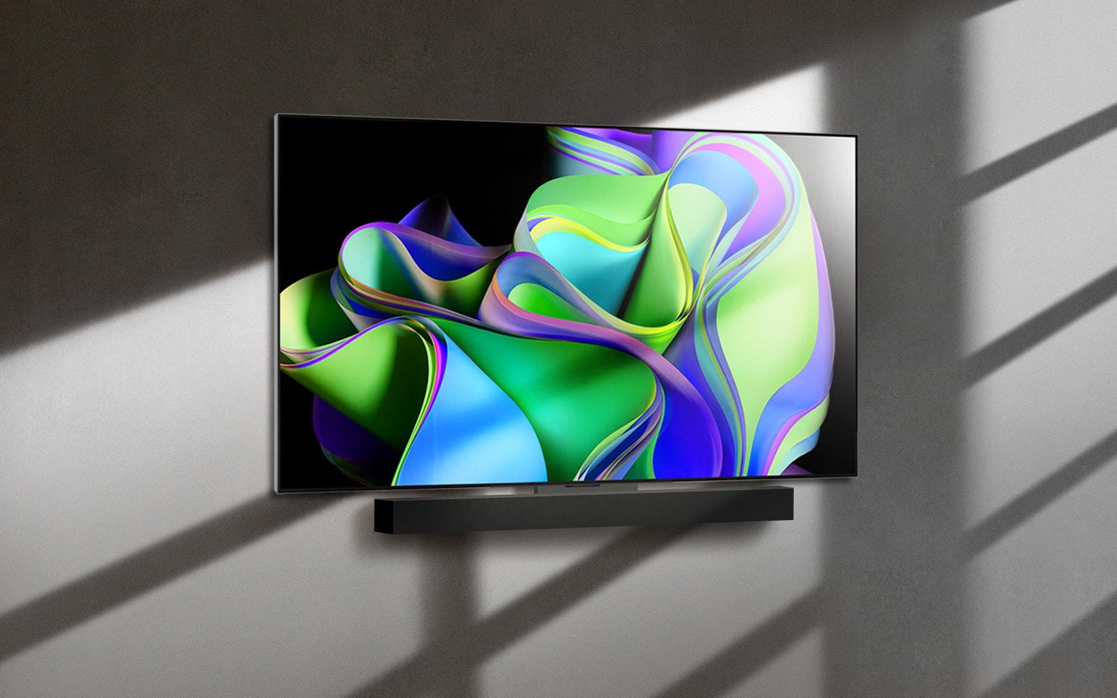 En video åpnes med ordene LG OLED evo mot en svart bakgrunn. Ordene forstørrer og fylles med farger. Deretter går scenen over til LG OLED C3, og viser et fargerikt abstrakt kunstverk med en Soundbar mot en hvit bakgrunn. Den hvite bakgrunnen blir en vegg i et rom som TV-en festes til.