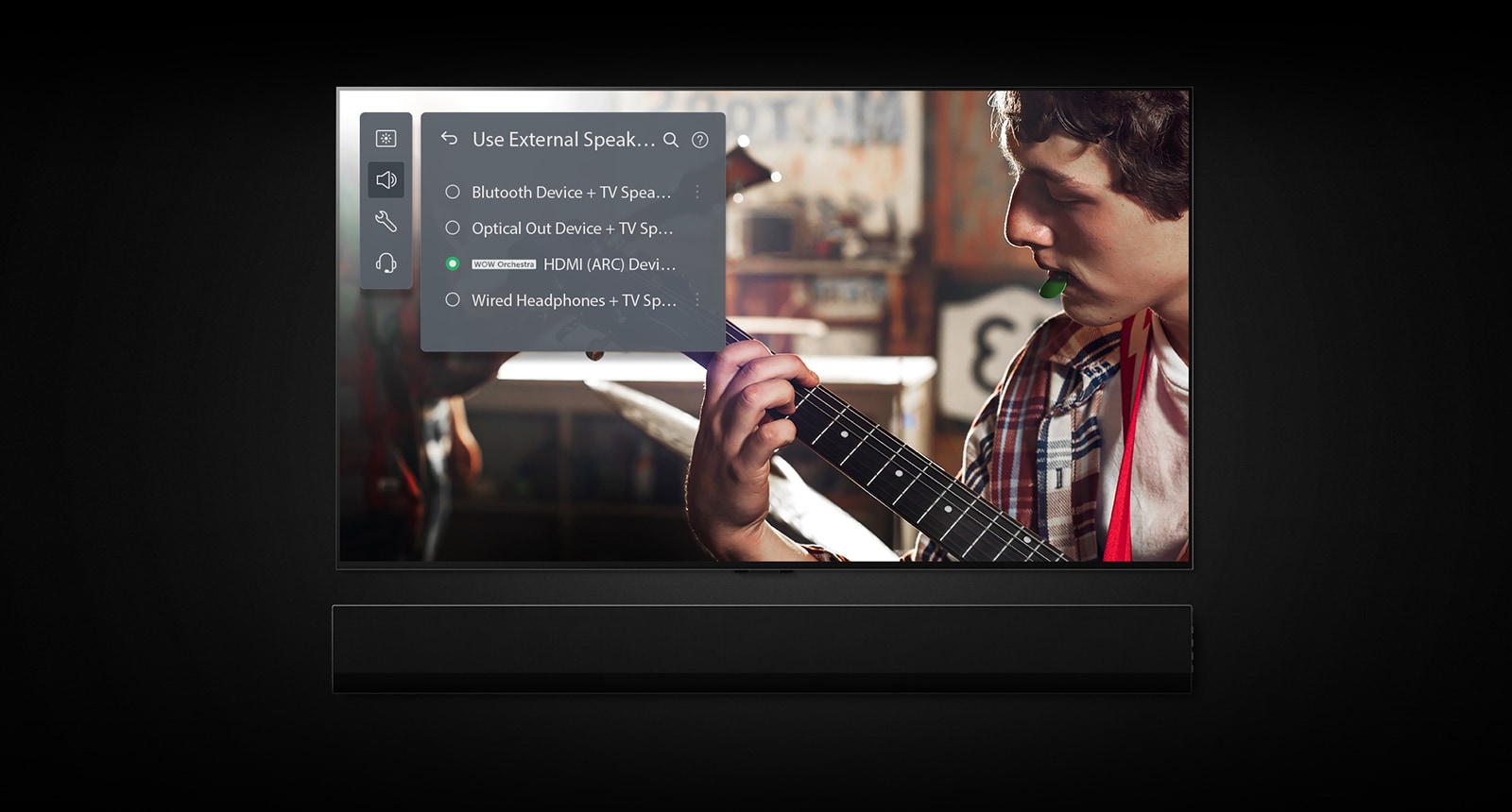 Et bilde av en LG OLED-TV med en lydplanke. En video av en gutt som spiller gitar spilles av på skjermen med innstillingene for lydplankemodus lagt over.